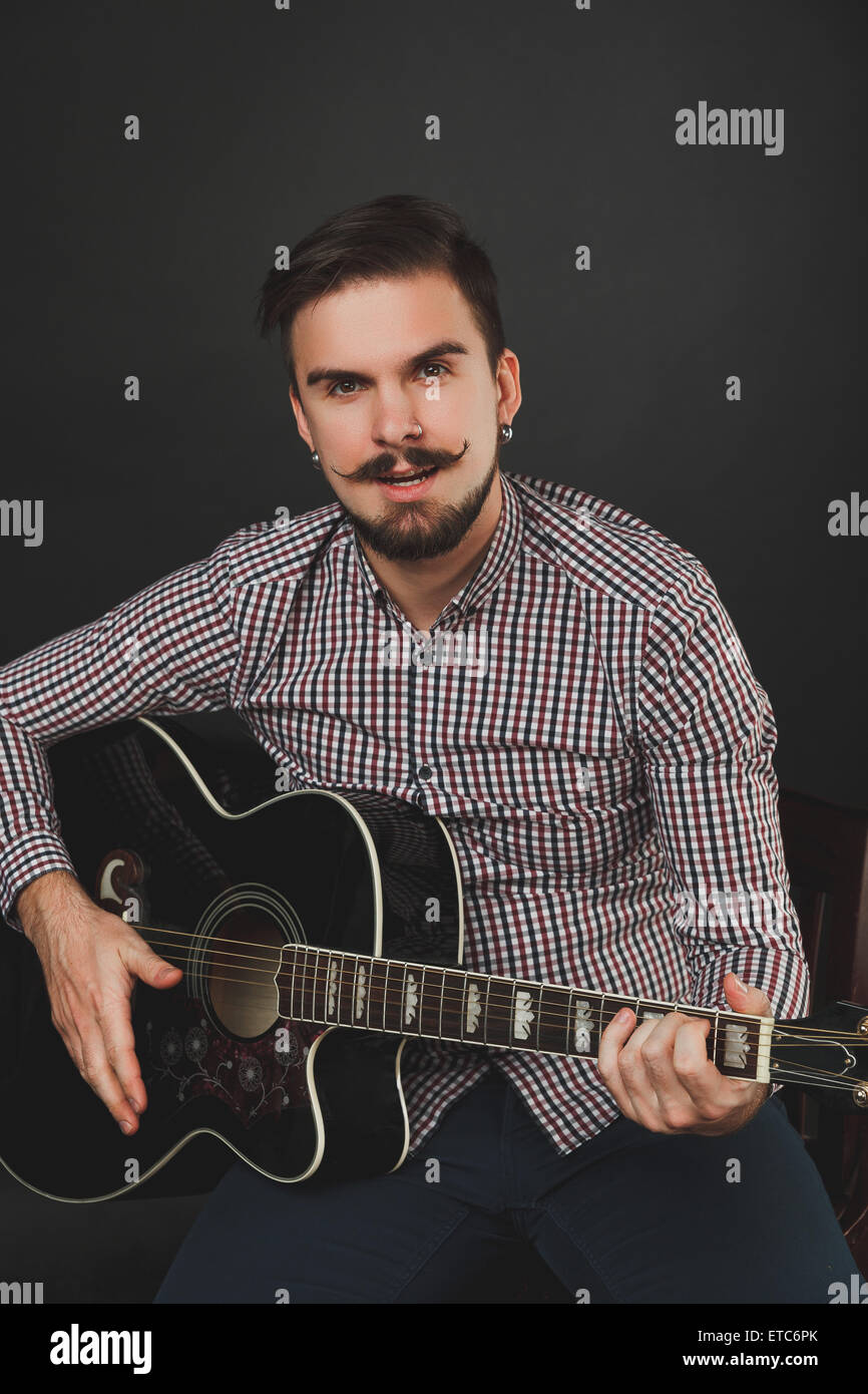handsome guy with beard holding acoustic guitar Stock Photo - Alamy