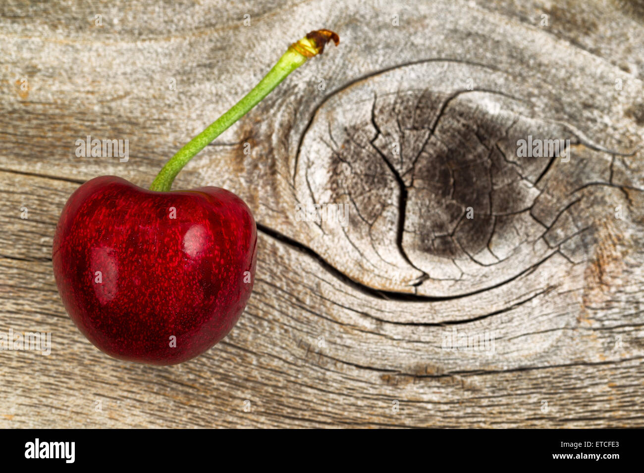 Close up of a single ripe large black cherry on rustic wood Stock Photo ...