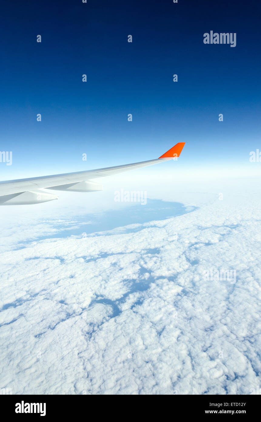Plane wing, white clouds and blue sky Stock Photo - Alamy