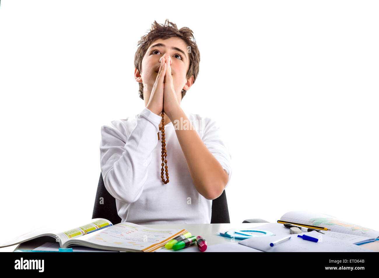 Caucasian boy is doing homework: sitting in front of a desk covered by ...