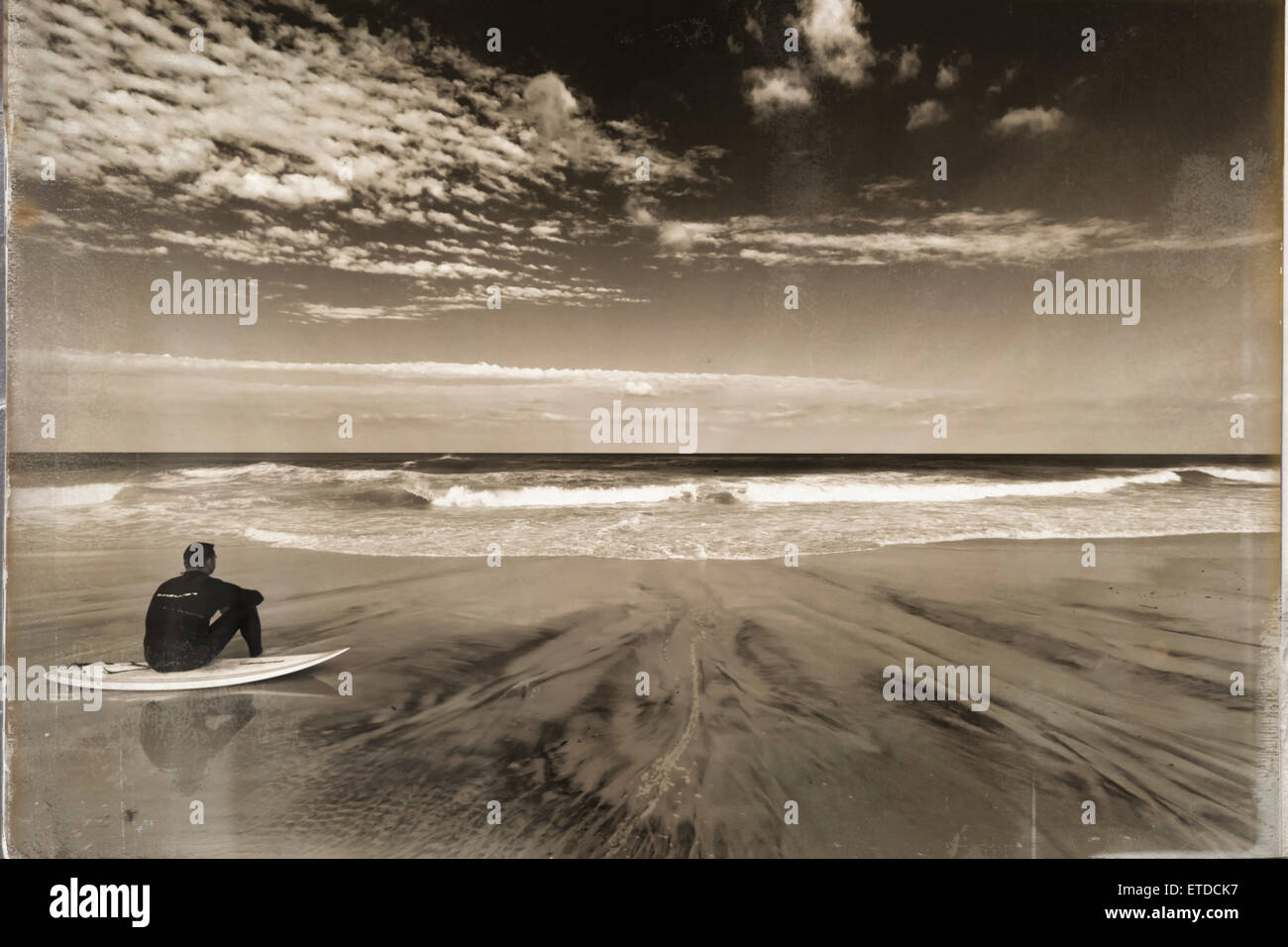 Sandy beach with a surfer Stock Photo - Alamy