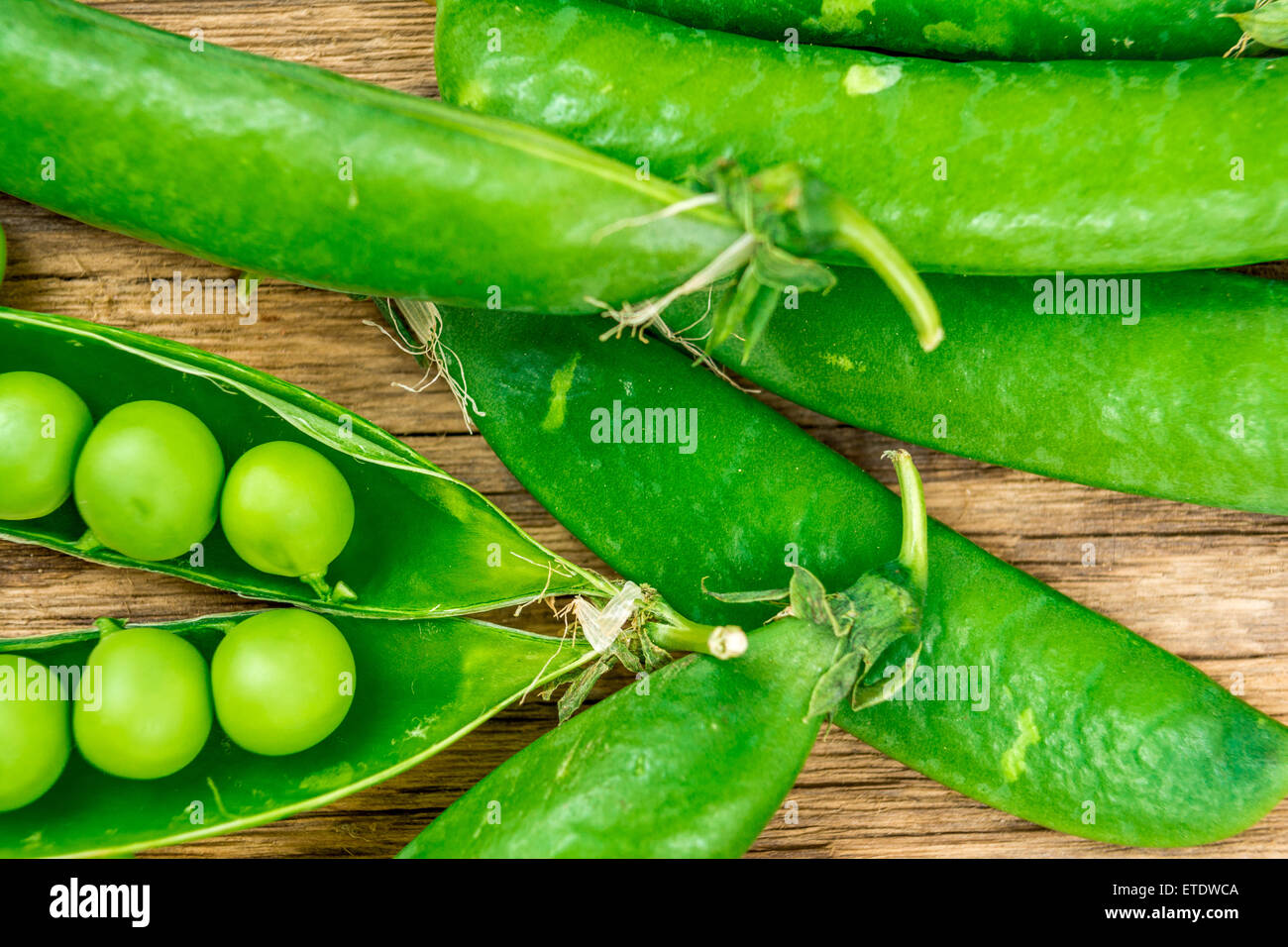 Many raw open pea on wood table Stock Photo - Alamy