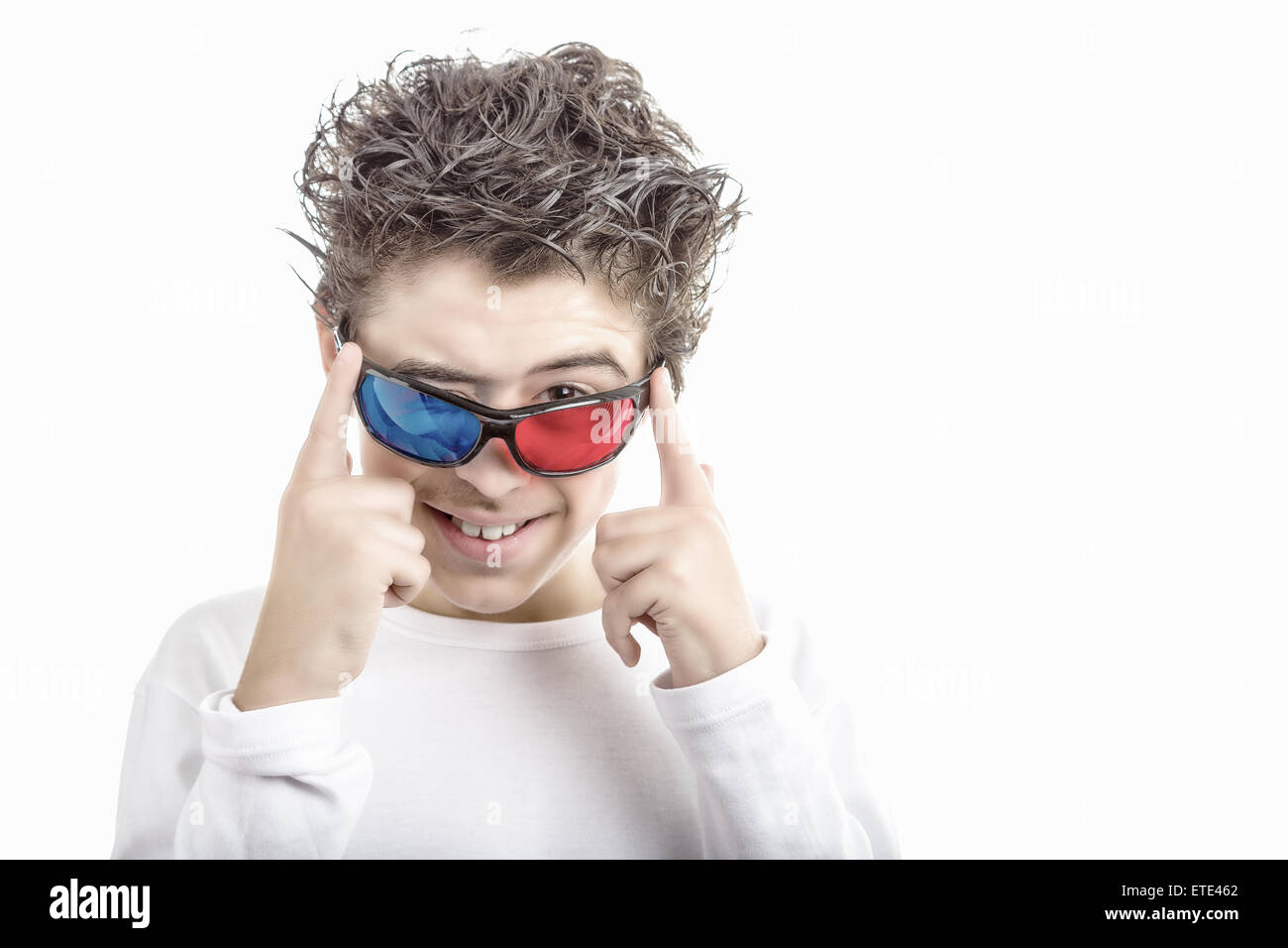 A cute Hispanic boy wears a pair of 3D Cinema eyeglasses with red and ...