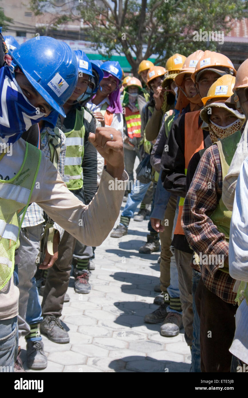 Construction workers take part in stretching exercises to enhance ...