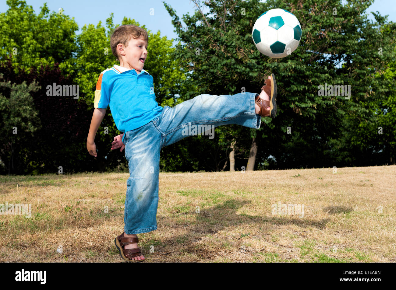 Little football player playing in the park with his father in football ...