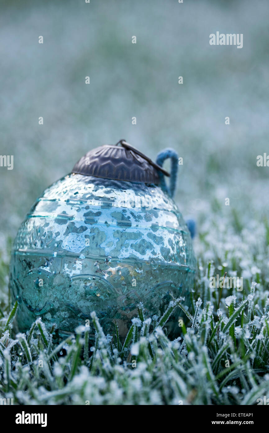 Christmas bauble in the grass on a cold, bright morning, with frost and ...