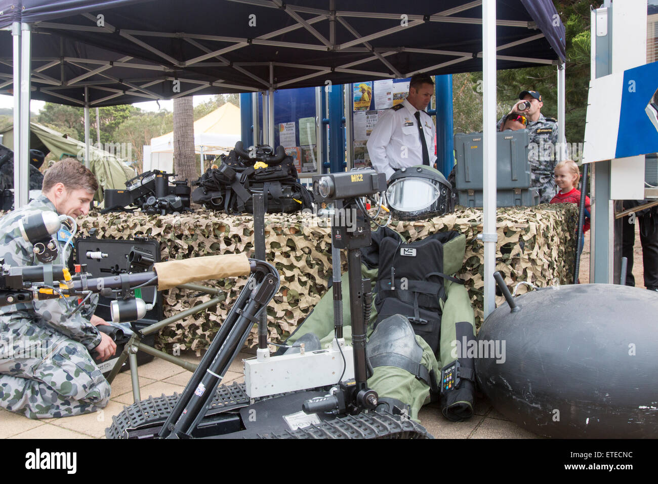 officers of the Royal australian navy demonstrate to a small child ...