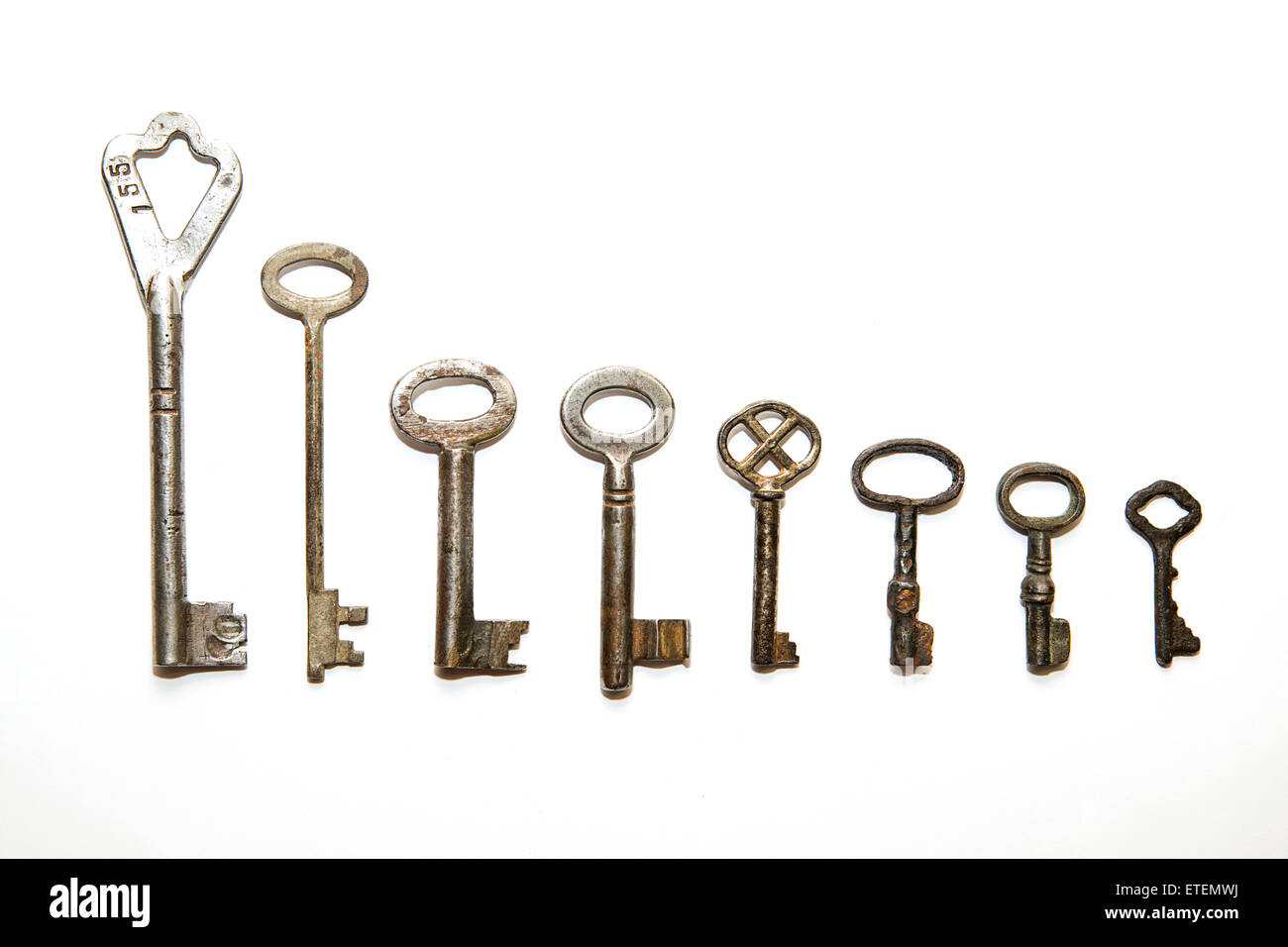 Many vintage keys to the safe on a white background Stock Photo - Alamy