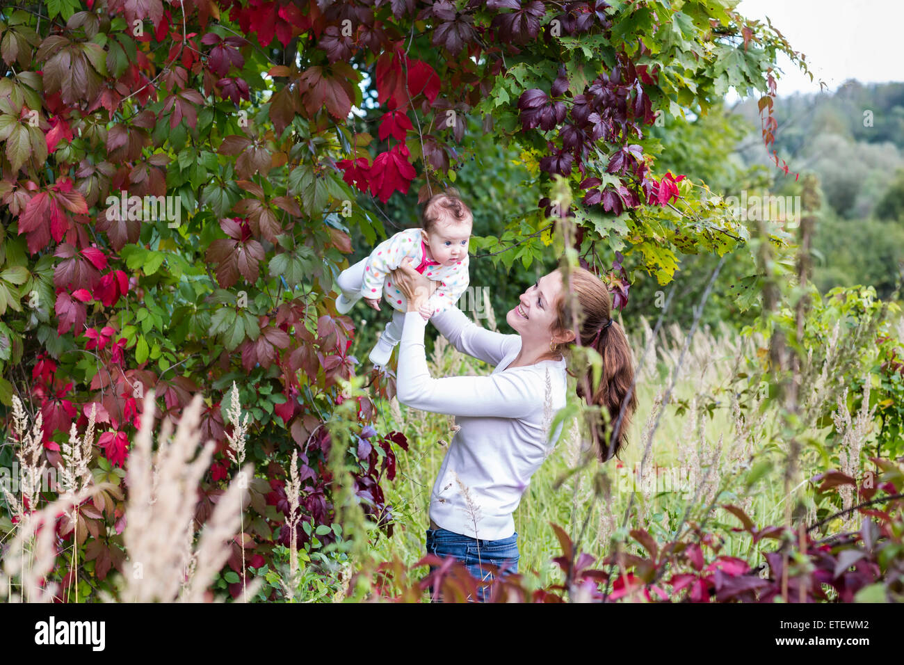Mother with her newborn baby in autumn scenery Stock Photo - Alamy