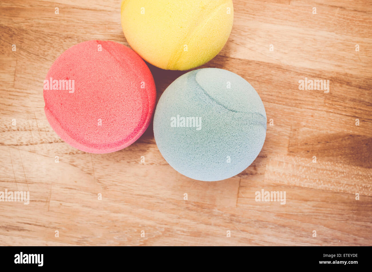 three soft foam rubber colored balls on a natural wood background Stock ...