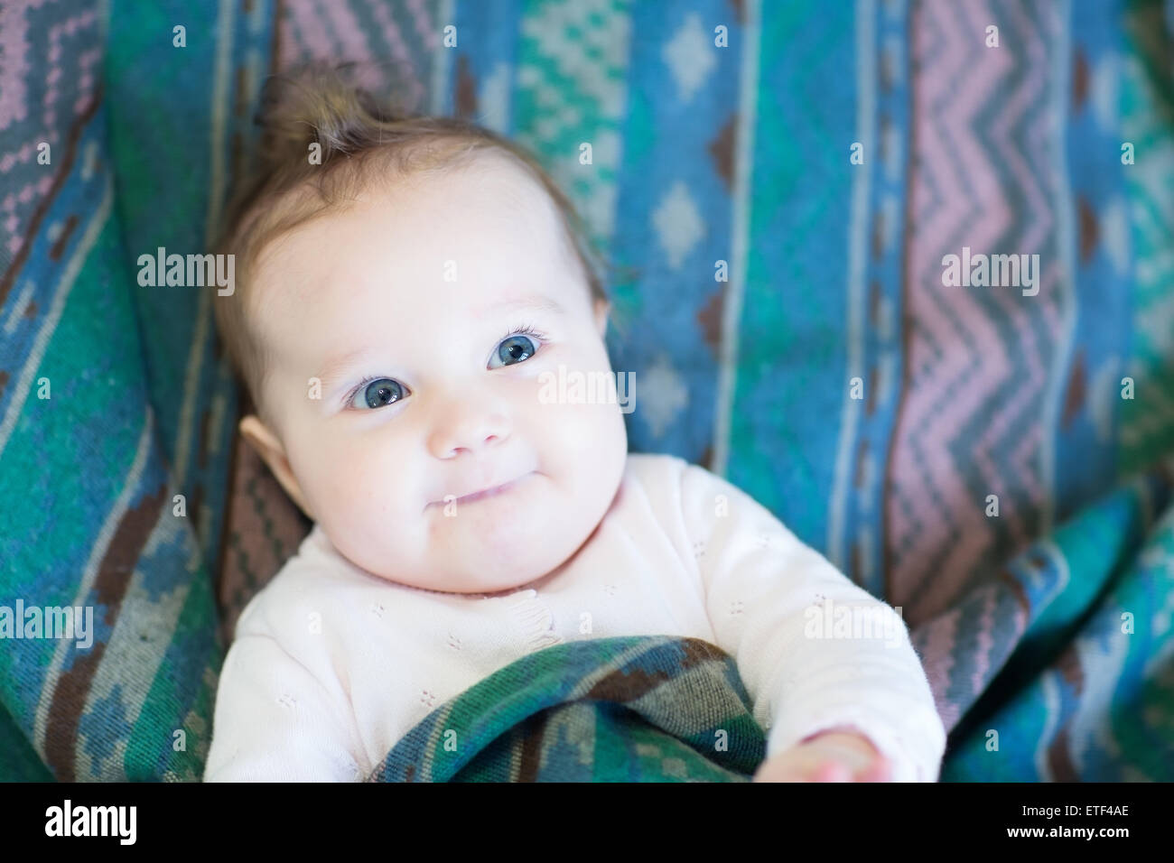 Curious little baby in a warm green blanket Stock Photo - Alamy