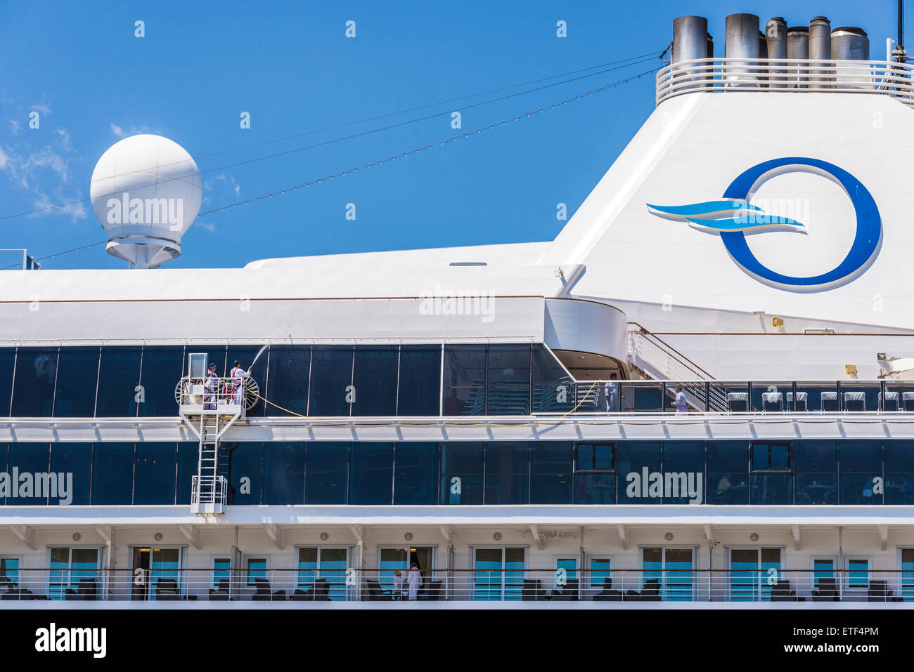 Two workers cleaning the windows on a raised platform of a cruise ship ...