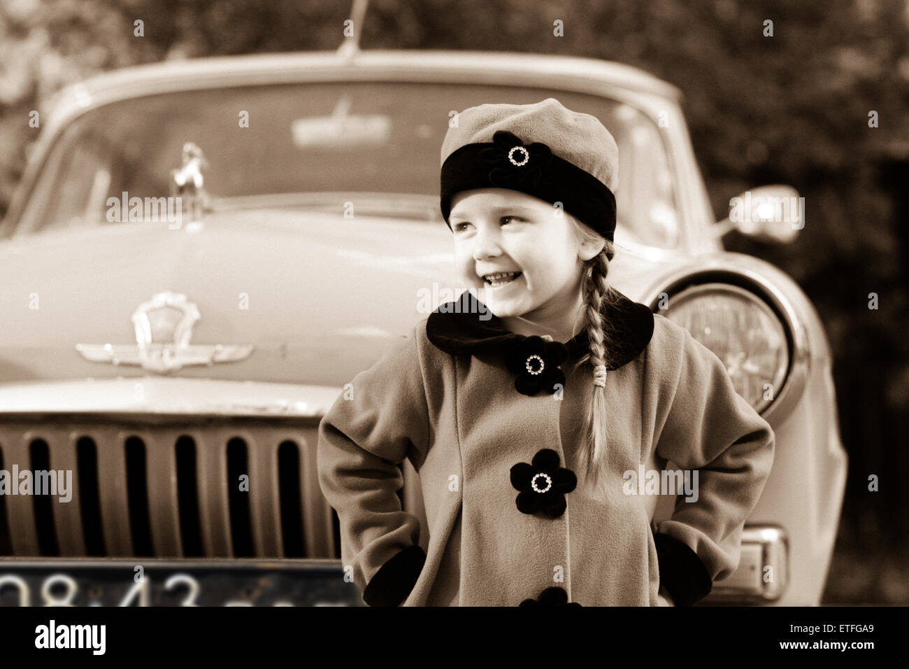 Cute little girl dressed in retro coat posing near oldtimer car, sixties Stock Photo - Alamy