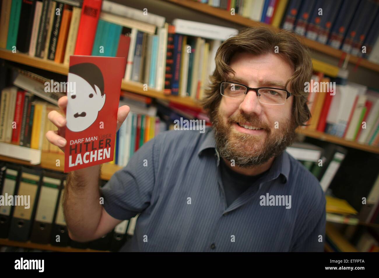 German philologist Carsten Jakobi holds up a flyer that reads 'Darf man ...