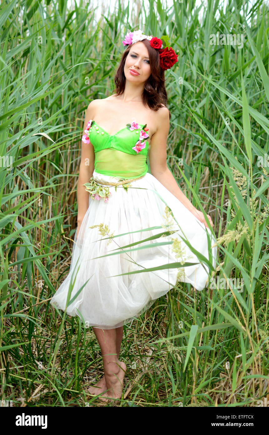 Barefoot woman surrounded by reeds. Model with chestnut hairs and ...