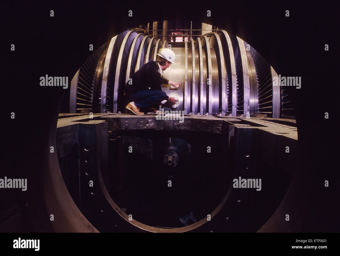 Male engineer inspecting the turbine rotors at a nuclear power plant ...