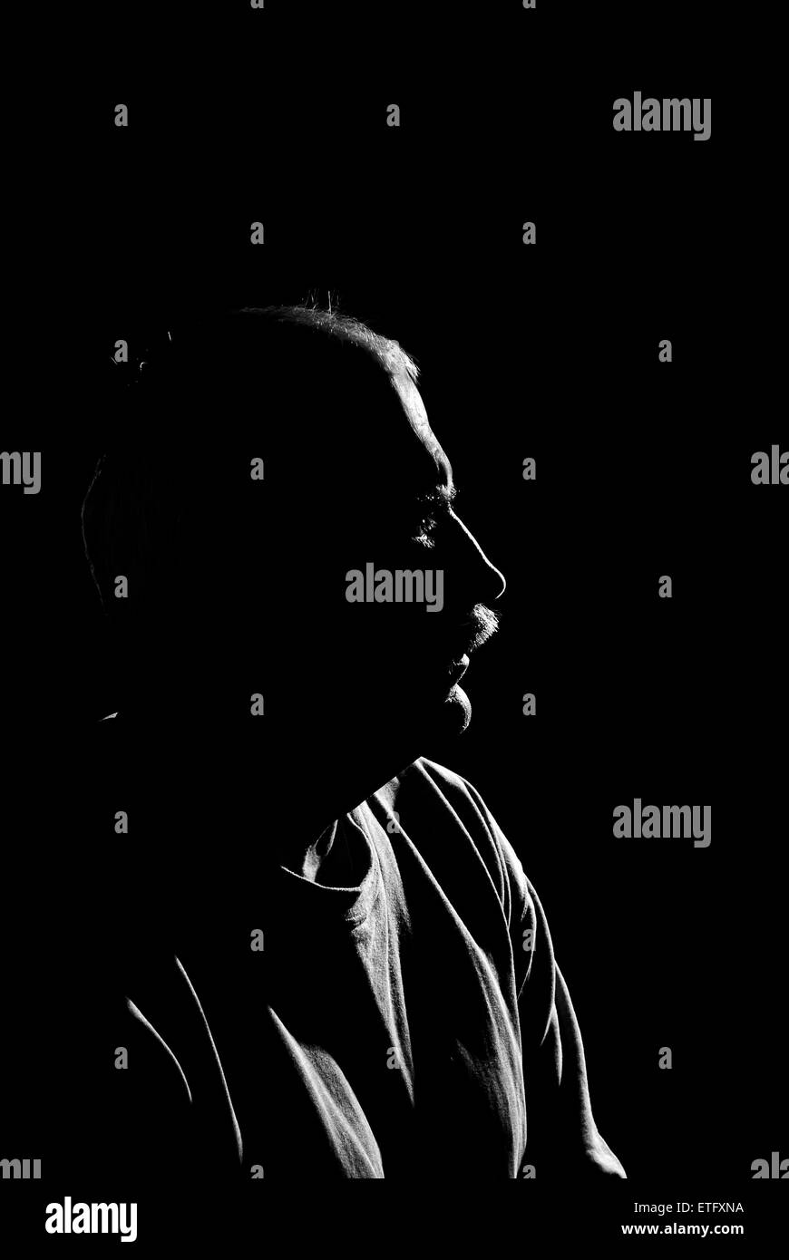 Black and white portrait (low key, face outline) of a Caucasian man ...