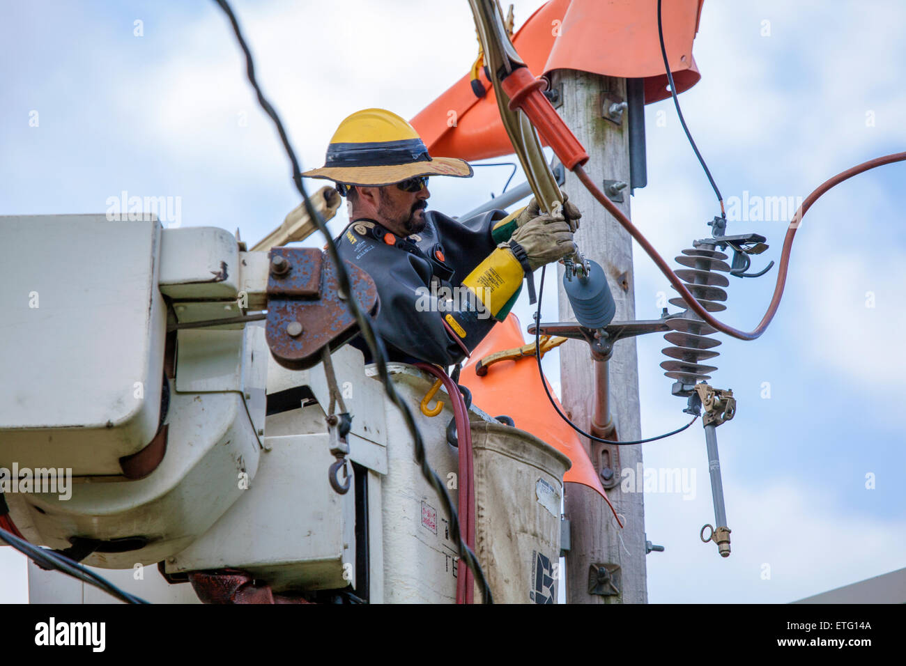 Lineman uses an elevated work platform called a 'cherry picker' to ...
