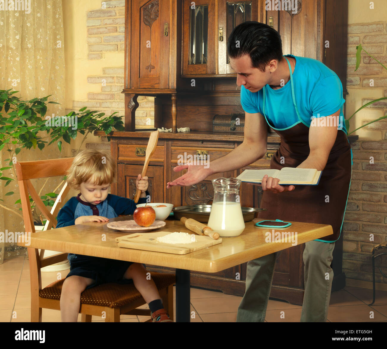 man with little boy in the kitchen preparing a meal. retro Stock Photo ...