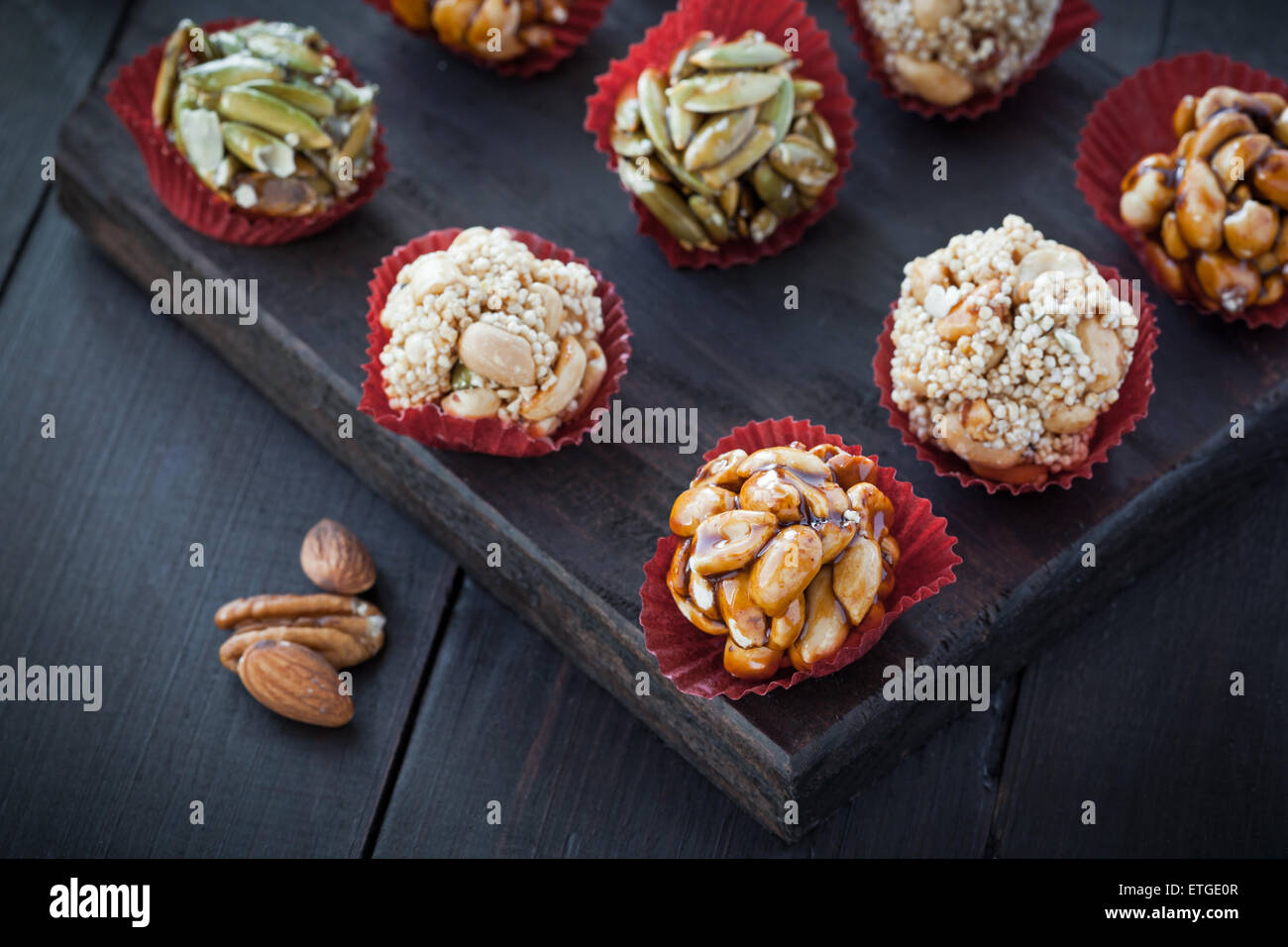 Candied caramelized nuts on cutting board on black wooden table Stock ...