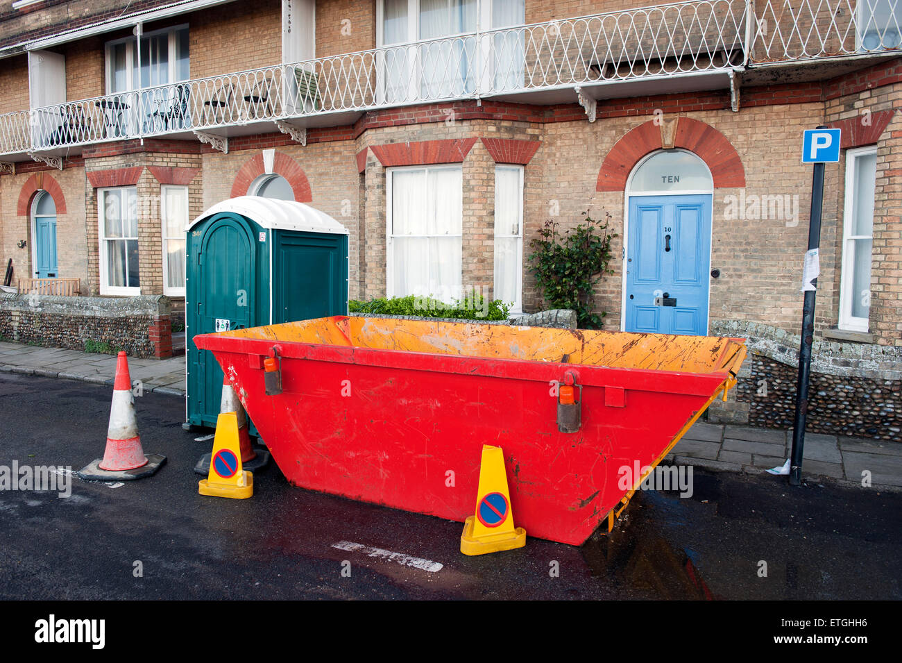 Refuse skip and portable toilet in front of a house in need of ...