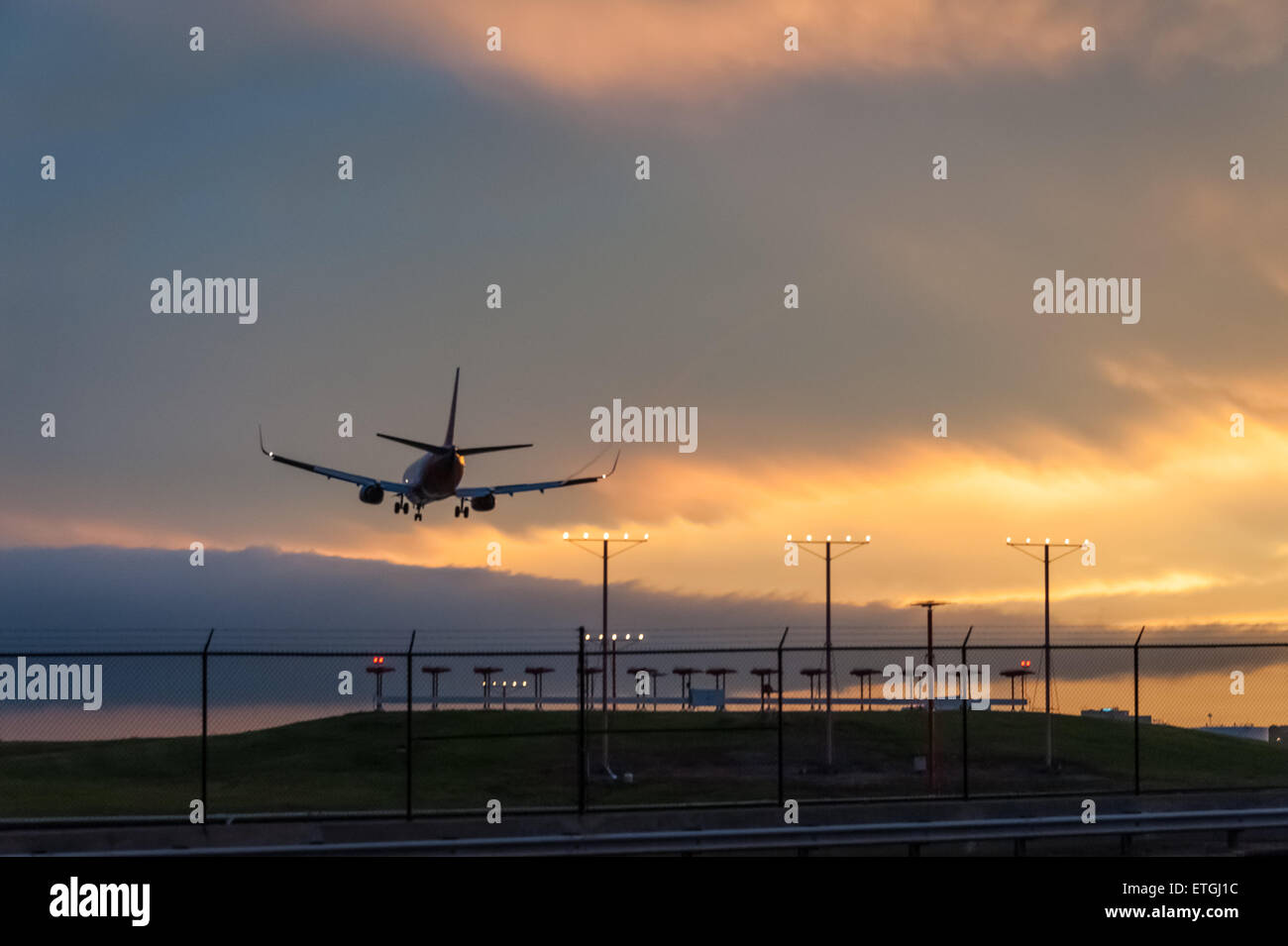 Passenger jet landing at Atlanta International Airport under a fiery ...