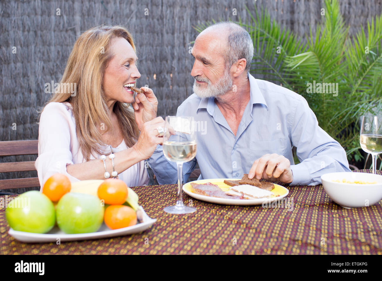 Elderly couple eating snacks in garden Stock Photo - Alamy