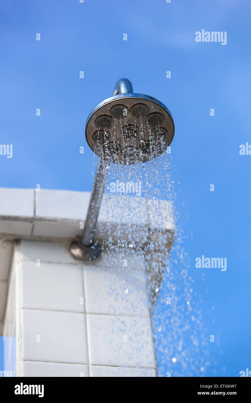 Water drops falling from a shower outside against blue sky Stock Photo ...