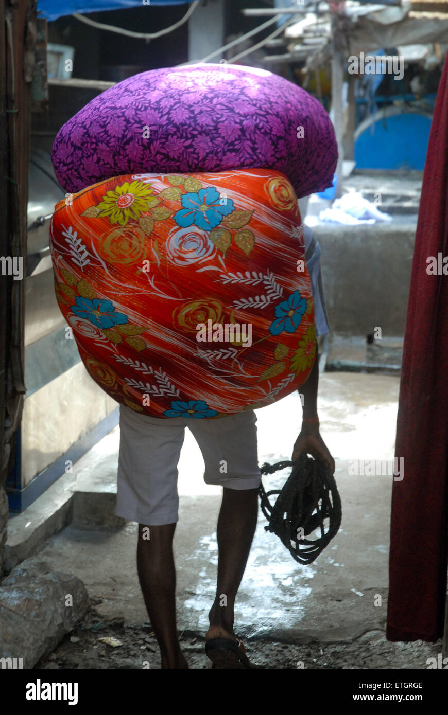 Man carrying bag of washing clothes at Mahalaxmi Dhobi Ghat open air ...