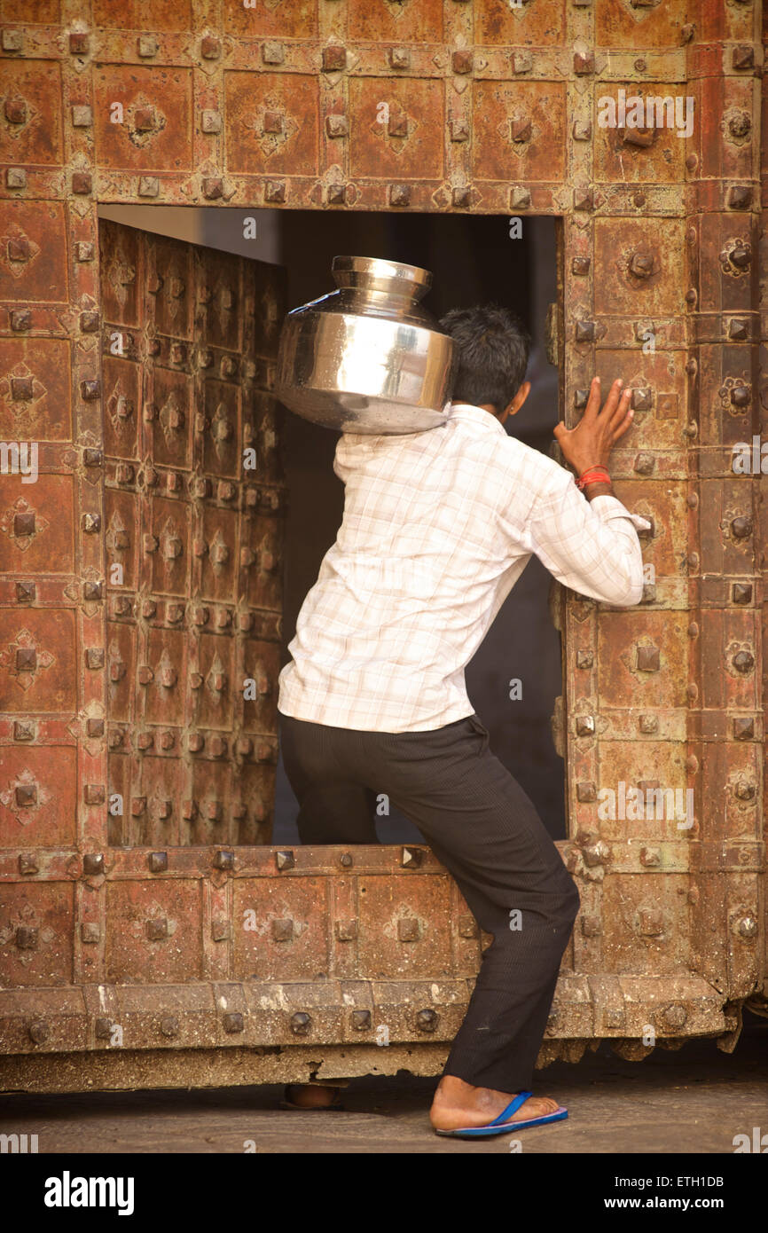 Man carrying urn of milk through studded door into Mehrangarh Fort ...