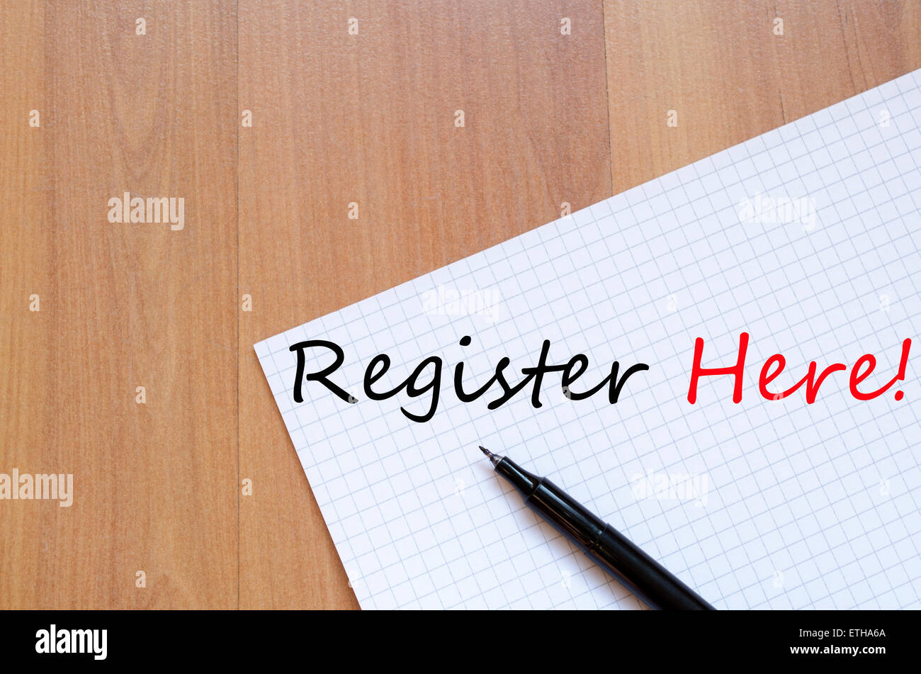 White blank notepad on office wooden table Register here concept Stock ...