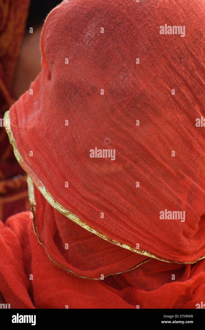 Indian woman screened behind red veil of her sari. Jodhpur, Rajasthan ...