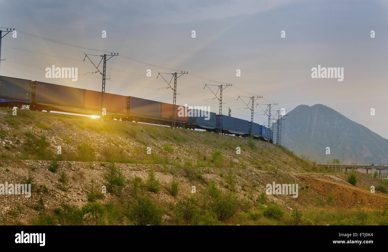 Freight train passing by on sunset beam Stock Photo - Alamy