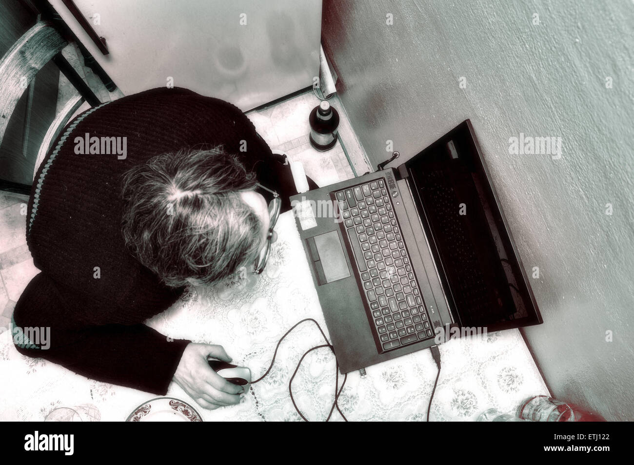 serious old man holding computer - he is working on a laptoptop view ...