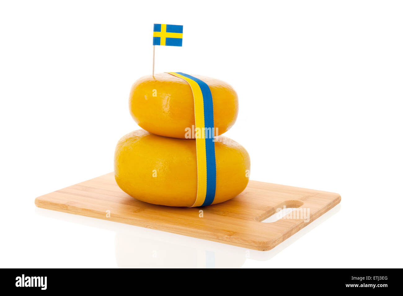 Two stacked whole Swedish cheeses isolated over white background Stock ...