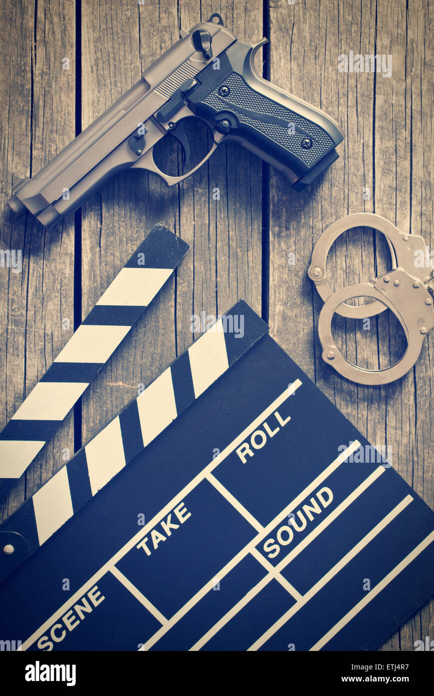 vintage photo shot of movie clapper and gun with handcuffs Stock Photo ...