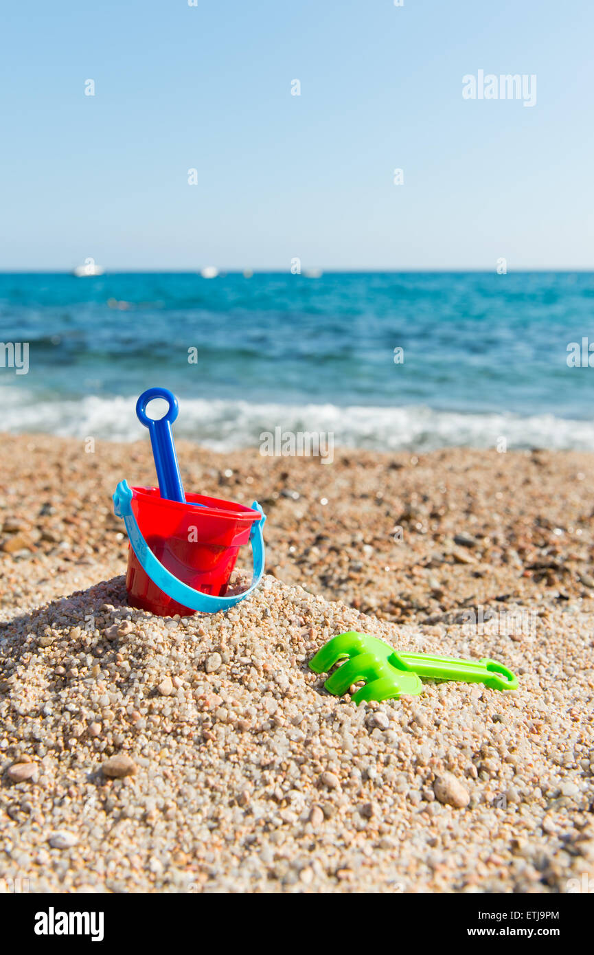red plastic toy bucket and rake at the beach Stock Photo - Alamy