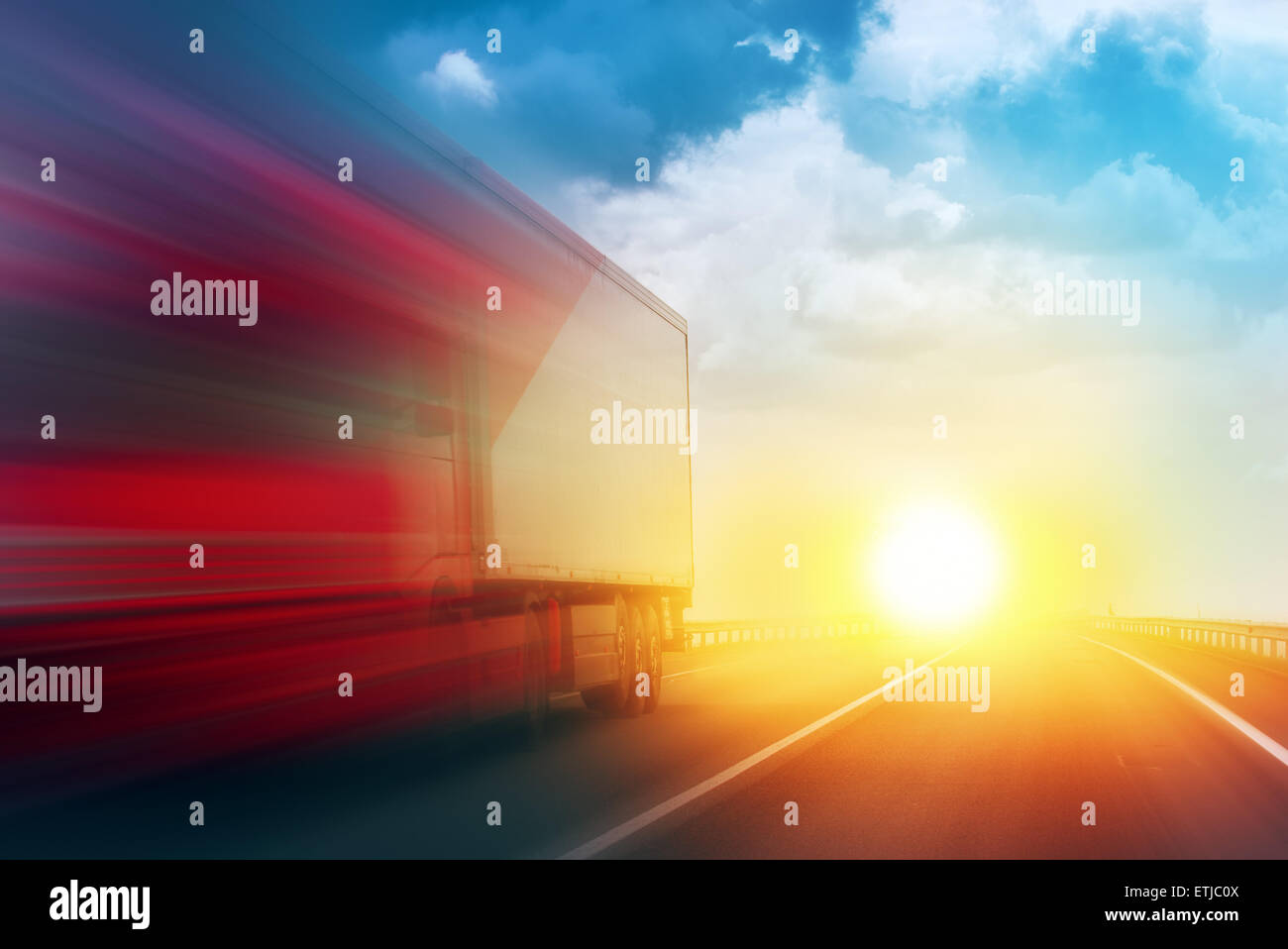 Speeding Transportation Delivery Truck on Open Highway with Sun Setting ...