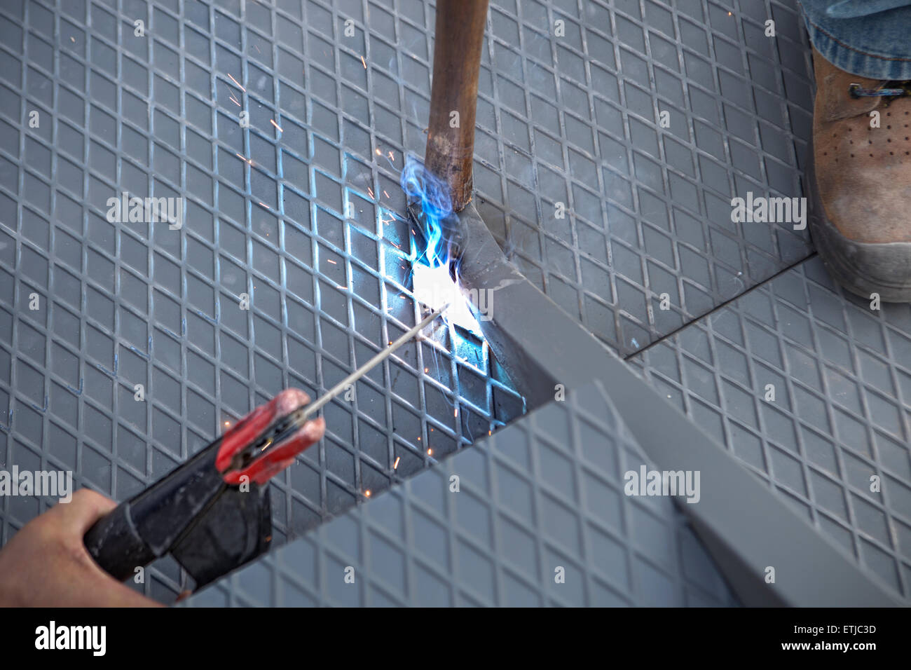 Two men working over iron platform with arc welding Stock Photo - Alamy