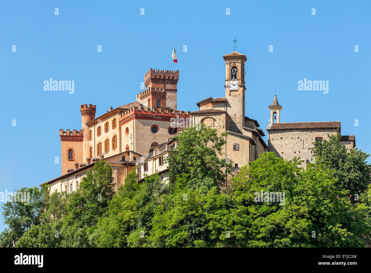 Medieval castle and parish church under blue sky in Barolo - small town ...