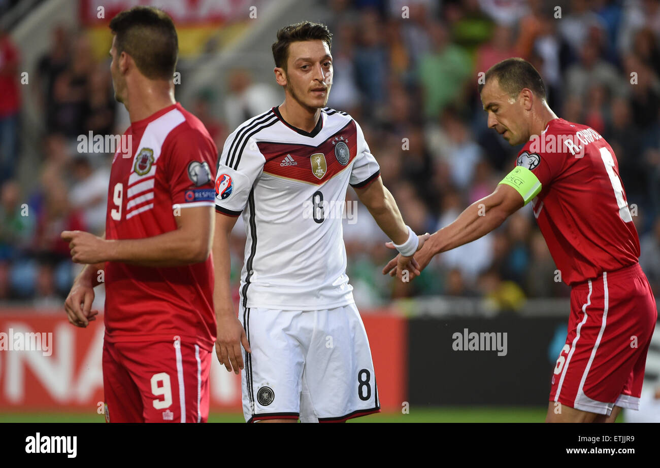 Germany's Mesut Oezil (C) and Roy Chipolina (R) from Gibraltar shake ...