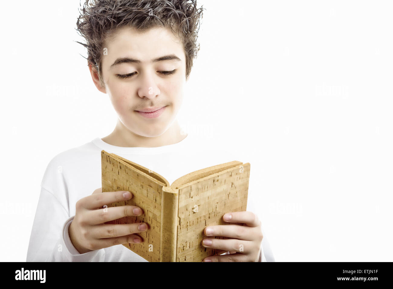 A handsome Hispanic boy smiles while reading a brown blank book made ...
