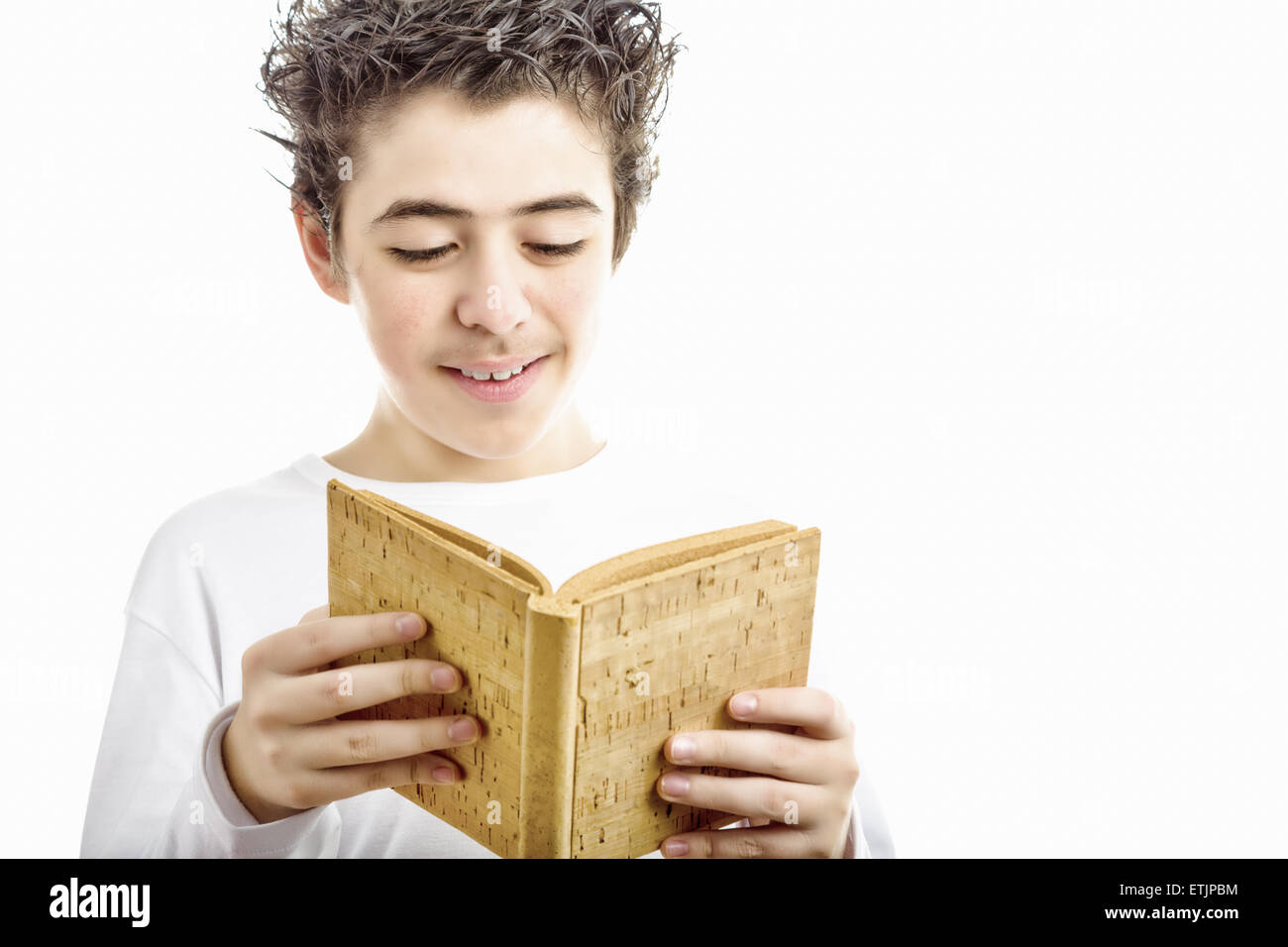 A handsome Hispanic boy smiles while reading a brown blank book made ...