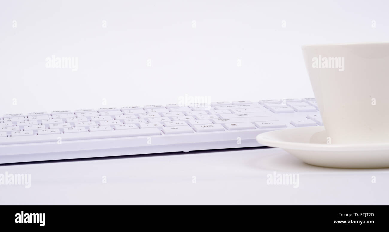 White computer keyboard and cup Stock Photo - Alamy