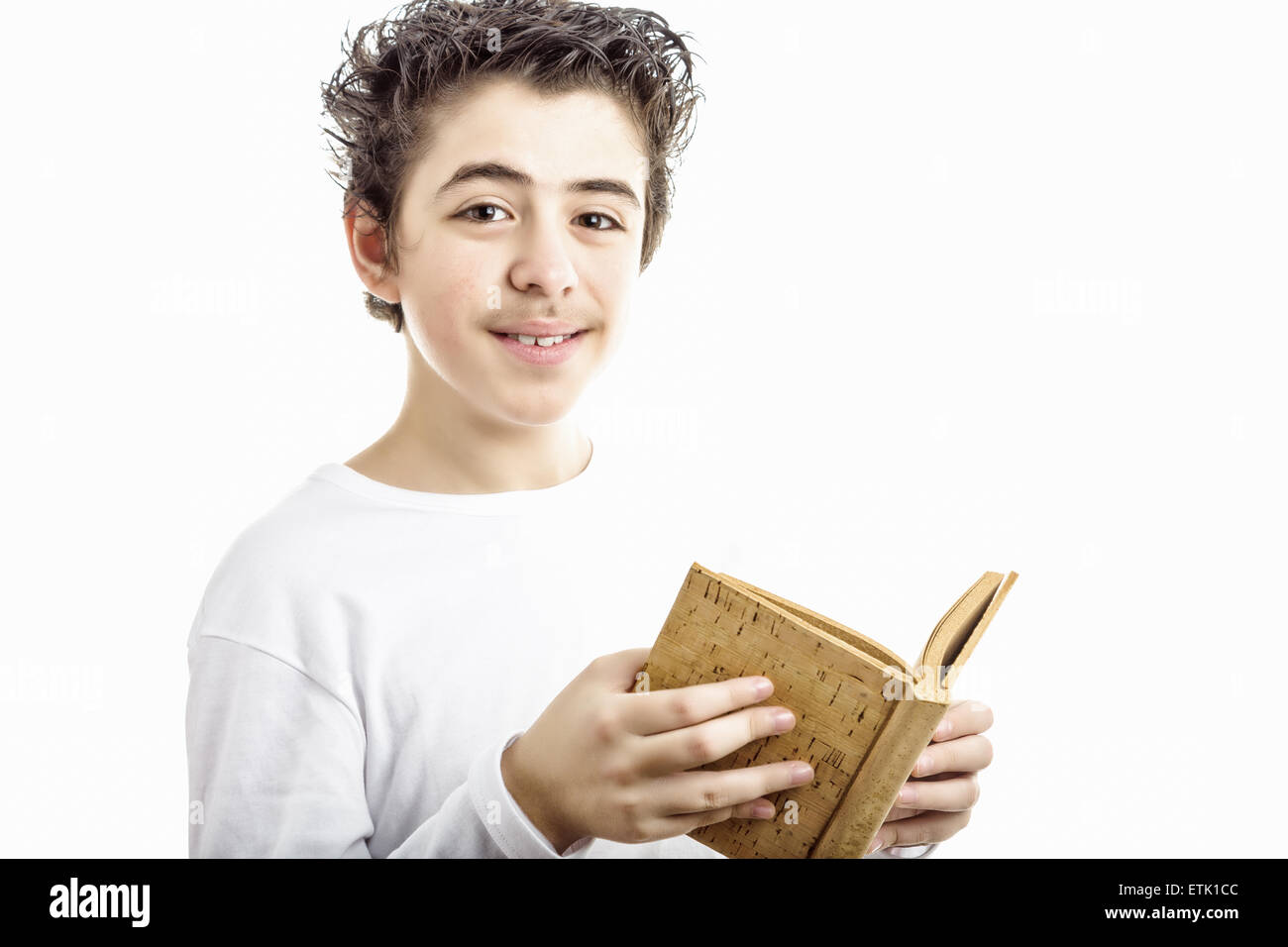 A handsome Hispanic boy smiles while reading a brown blank book made ...