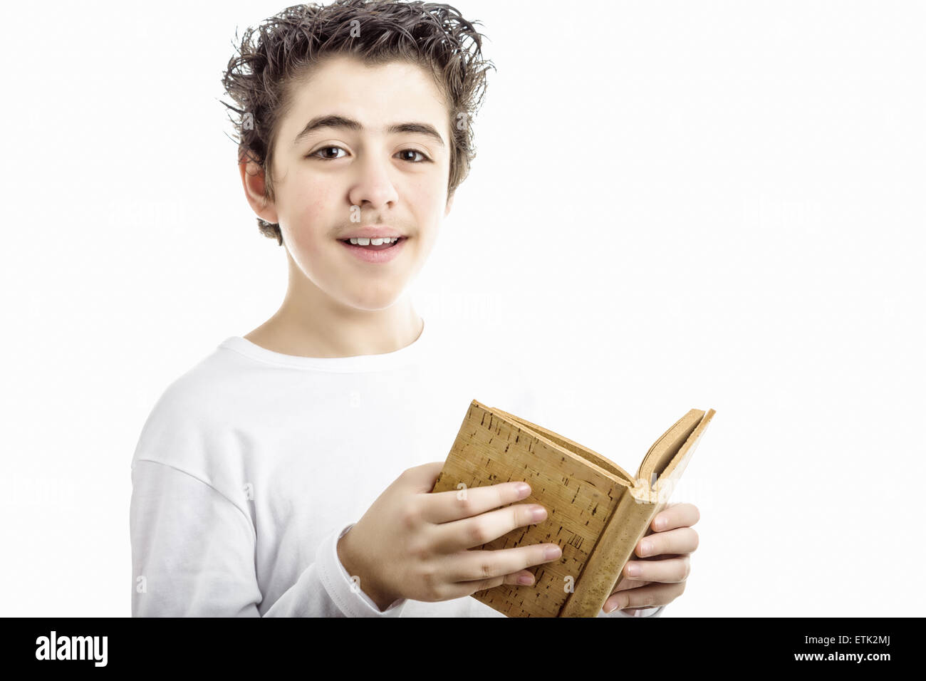 A handsome Hispanic boy smiles while reading a brown blank book made ...