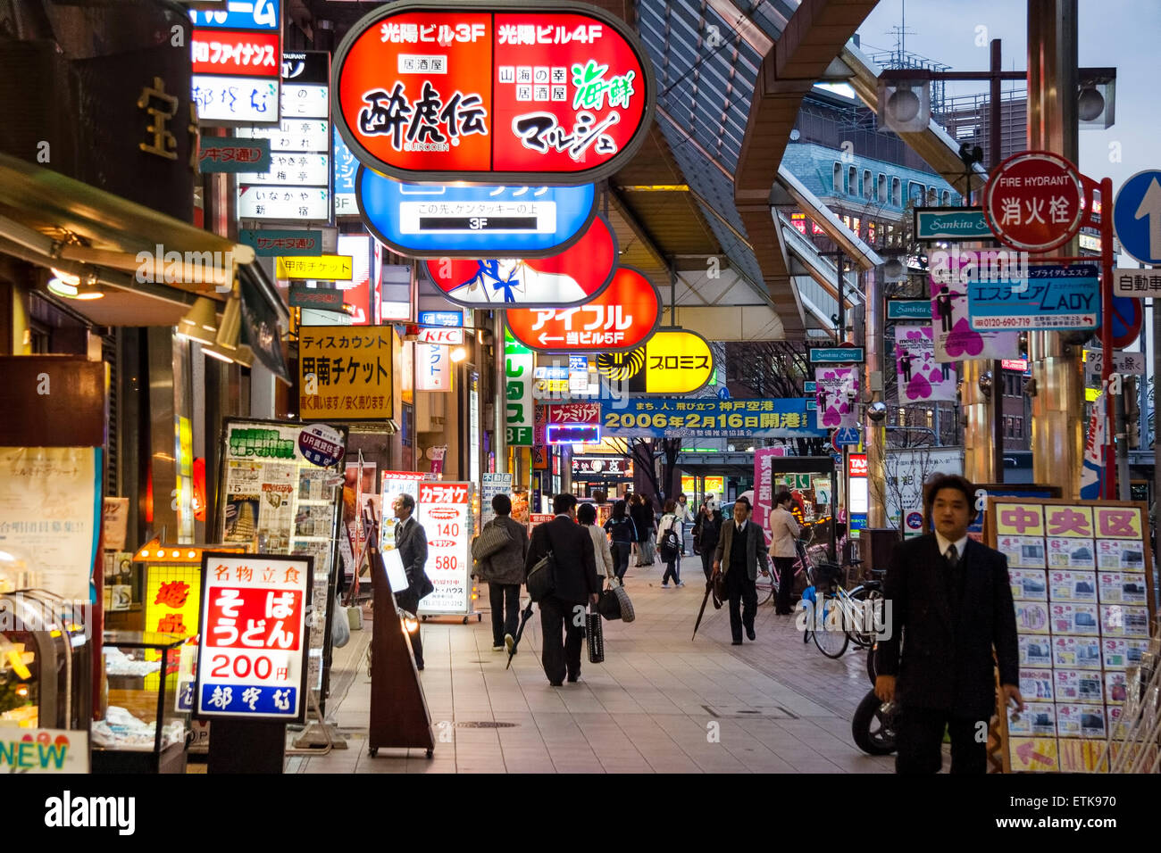 Blue hour view along partly covered pavement with people and row of ...