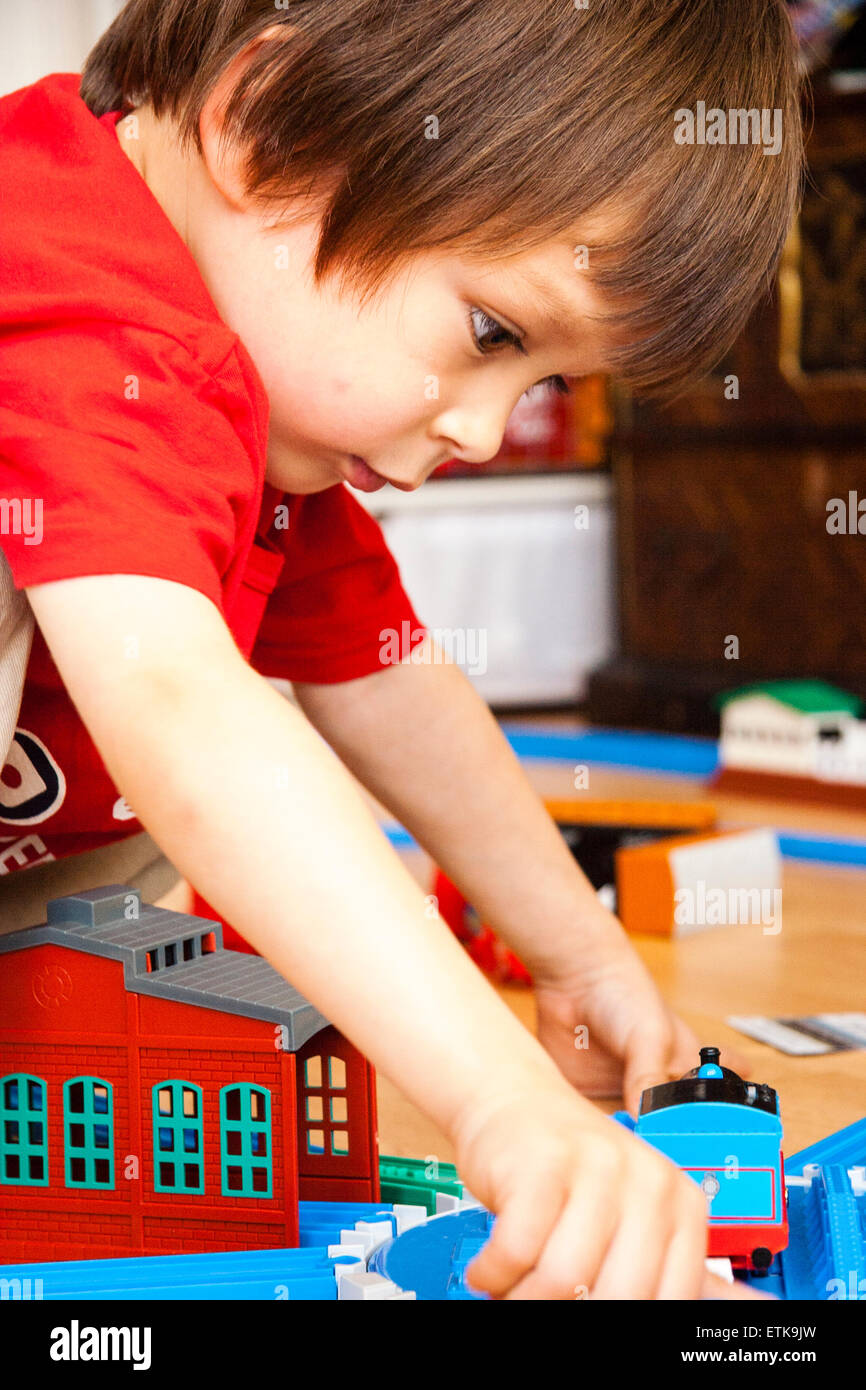 Caucasian child, boy, 4-5 year old, kneeling down on wooden floor ...