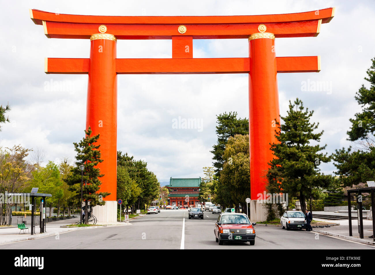 The giant orange torii spanning the main road in front of the tree ...
