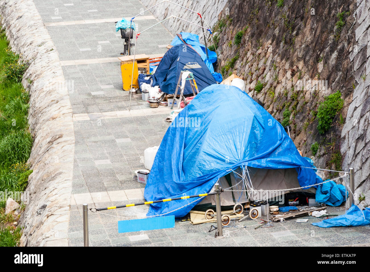 Japan, Kyoto. Blue tarpaulin self made homeless shelters on the city ...